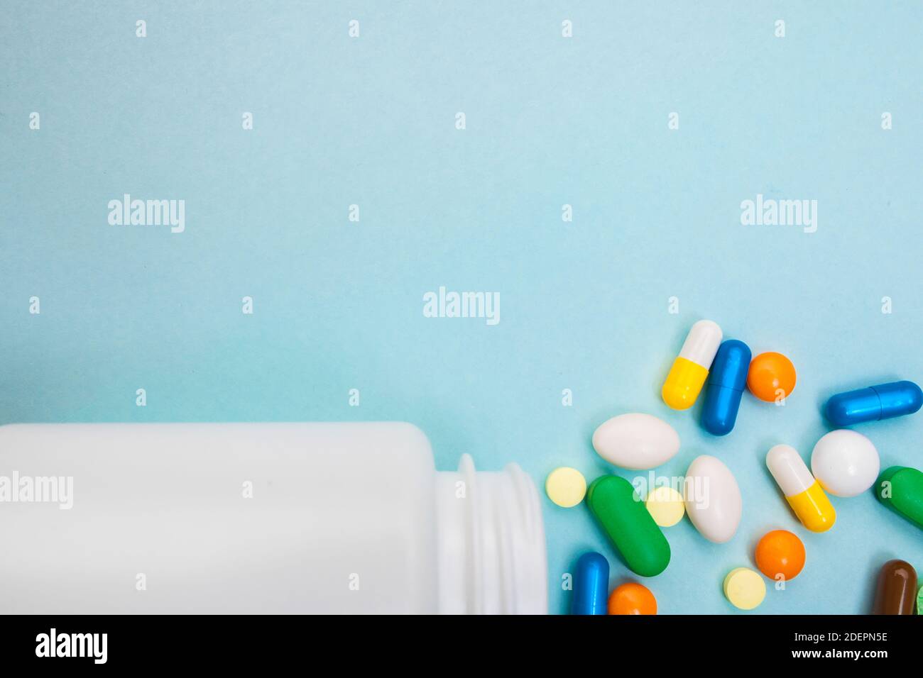 Multi-colored tablets and capsules, white bottle for tablets ...