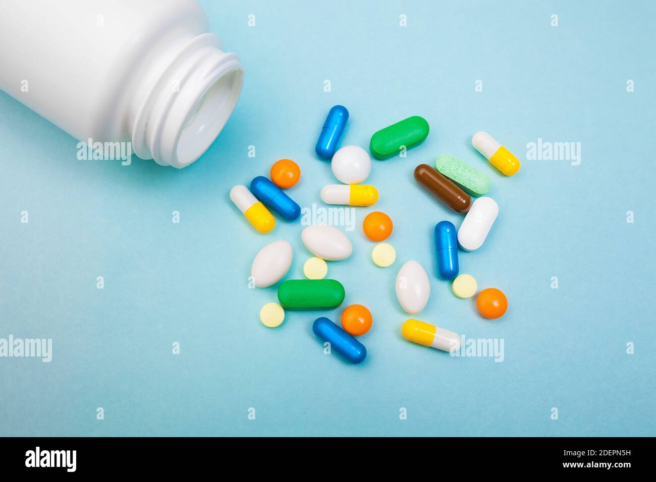 Multi-colored tablets and capsules, white bottle for tablets ...