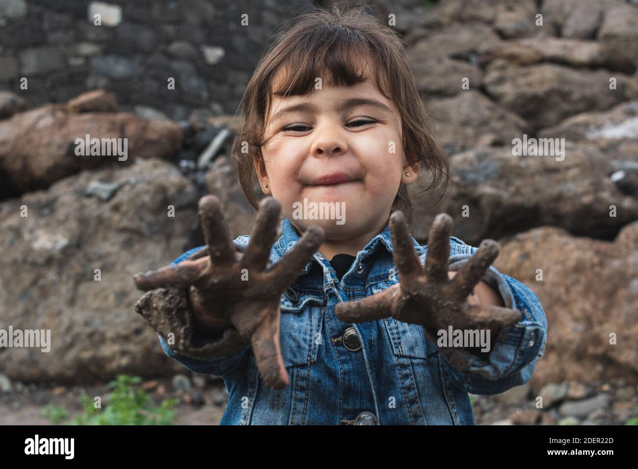 A little girl showing muddy hands after jumping in muddy puddles Stock ...