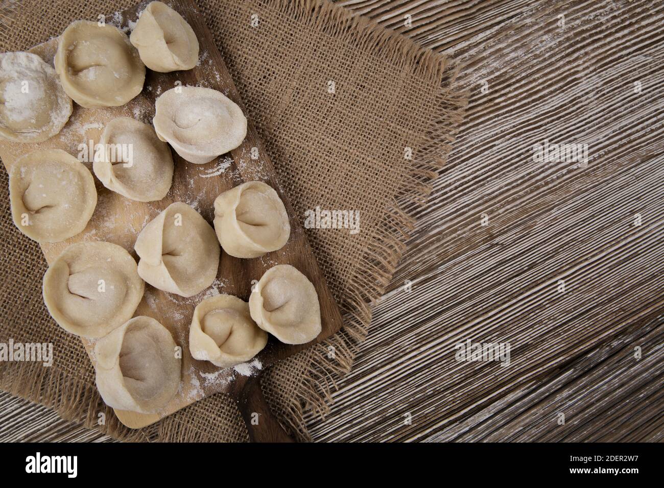 wooden food board with dumplings stands on burlap on the table Stock ...