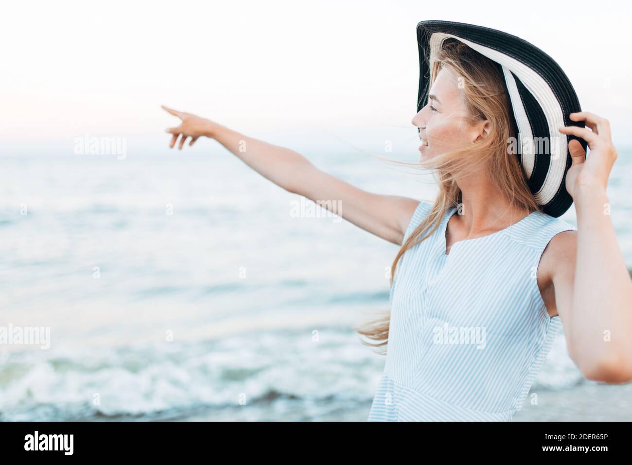 girl on the background of the sea, points to something with your finger ...