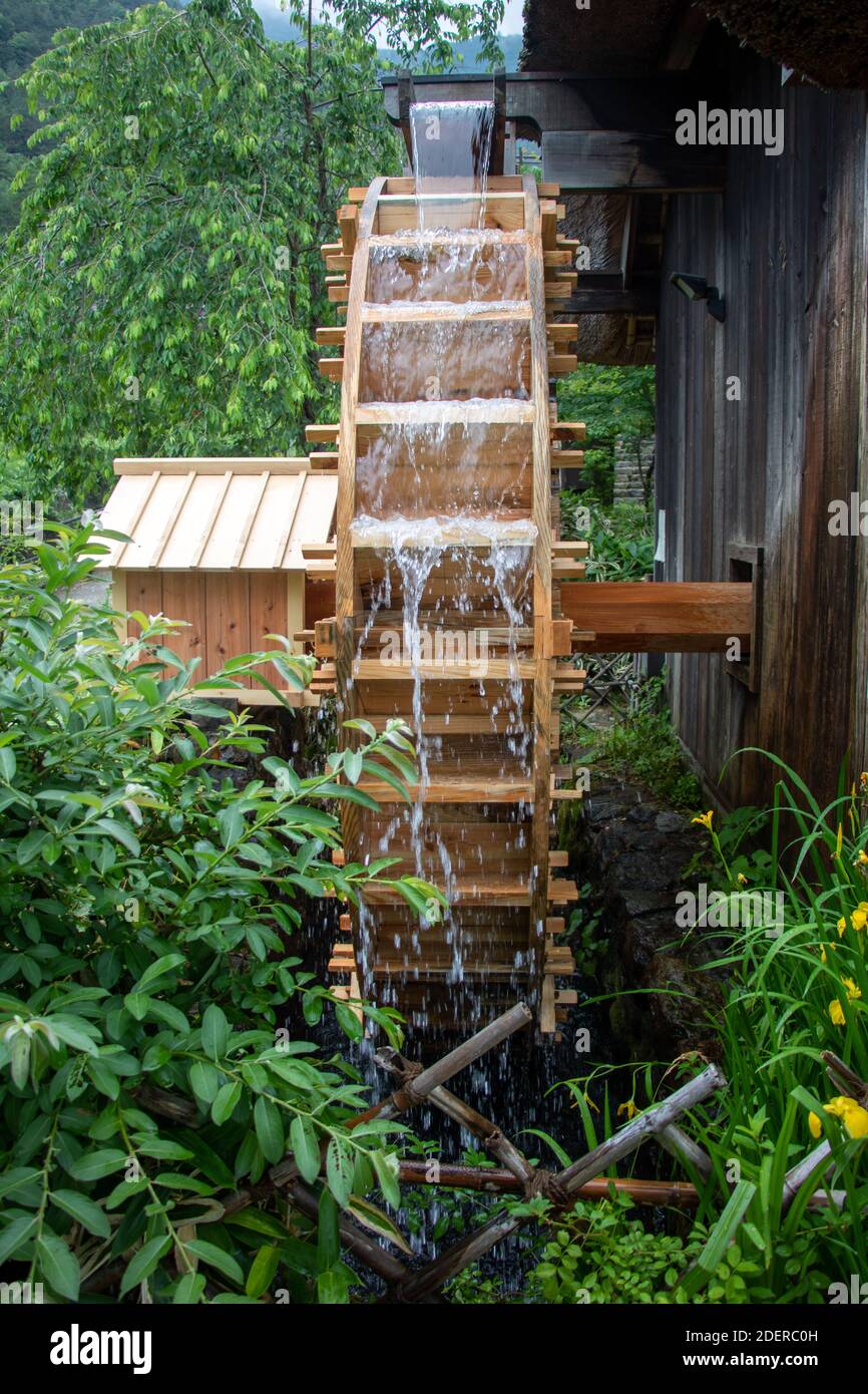 The mill wheel rotates under a stream of water Stock Photo - Alamy