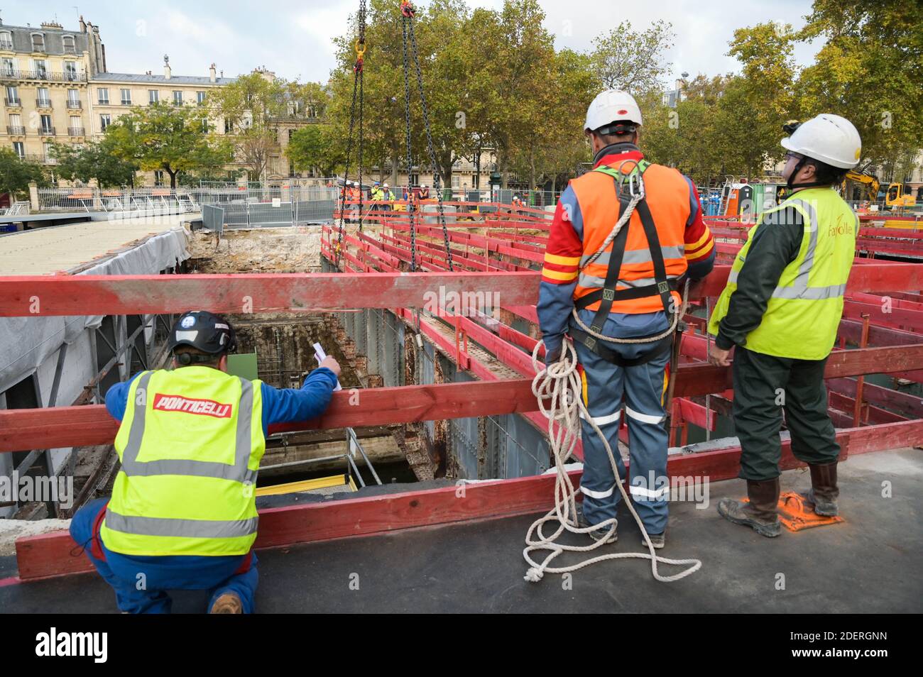 Workers look at a beam as they get ready to move it during the visit of ...