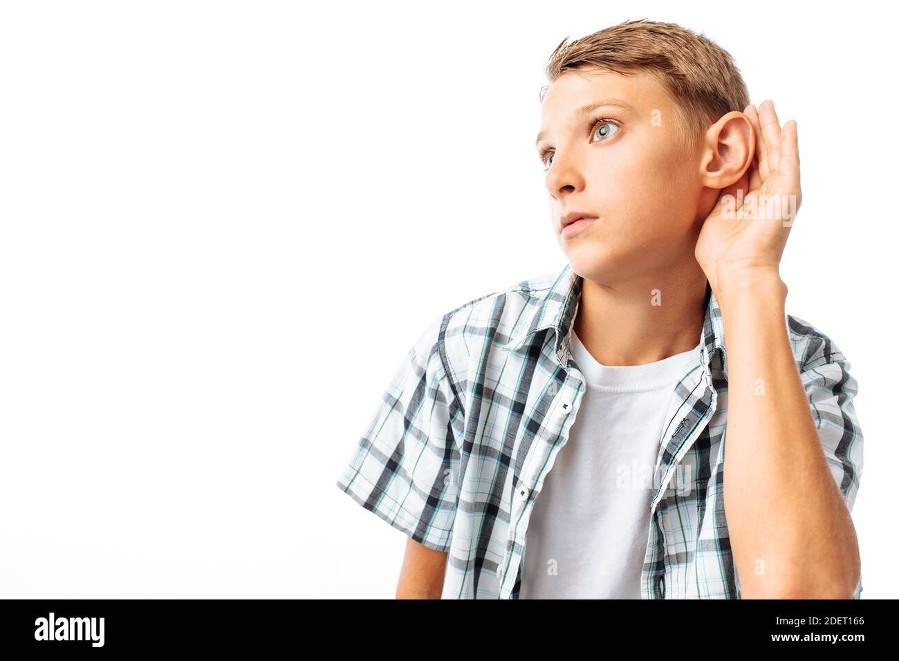 the boy overhears, put his hand to his ear to hear better, in the ...