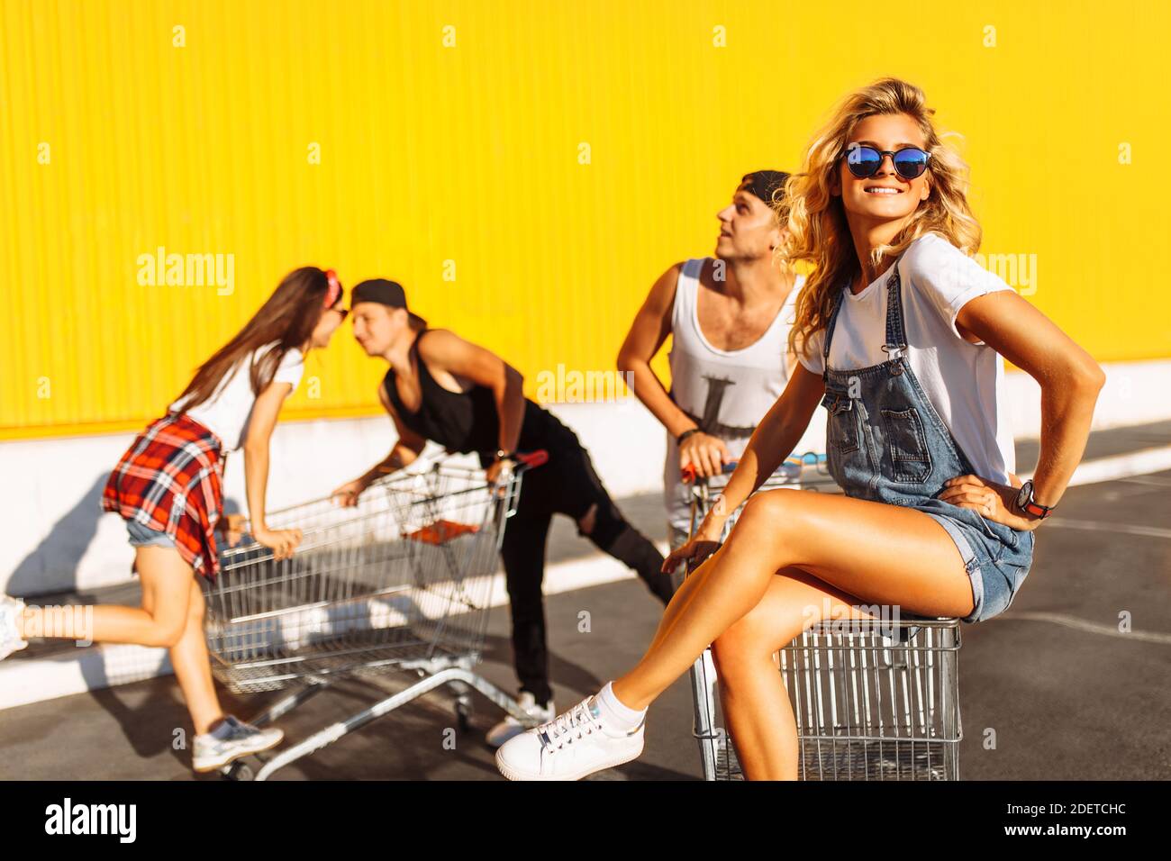 Friends ride on carts, near the supermarket, a great pastime, a group ...