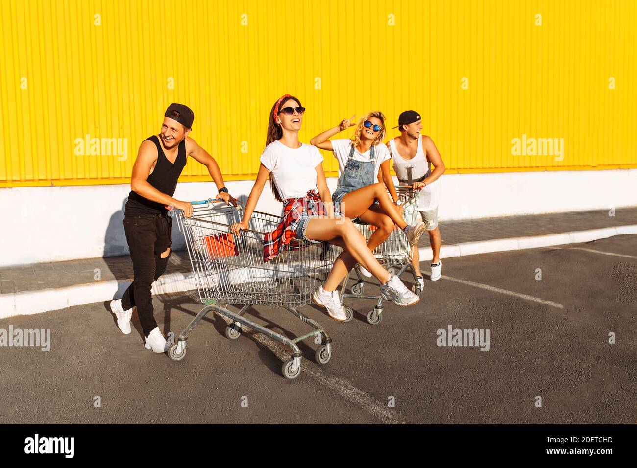 Friends ride on carts, near the supermarket, a great pastime, a group ...