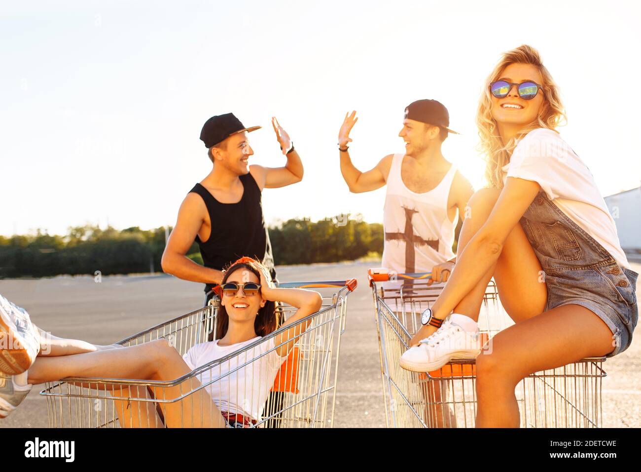 Friends ride on carts, near the supermarket, a great pastime, a group ...