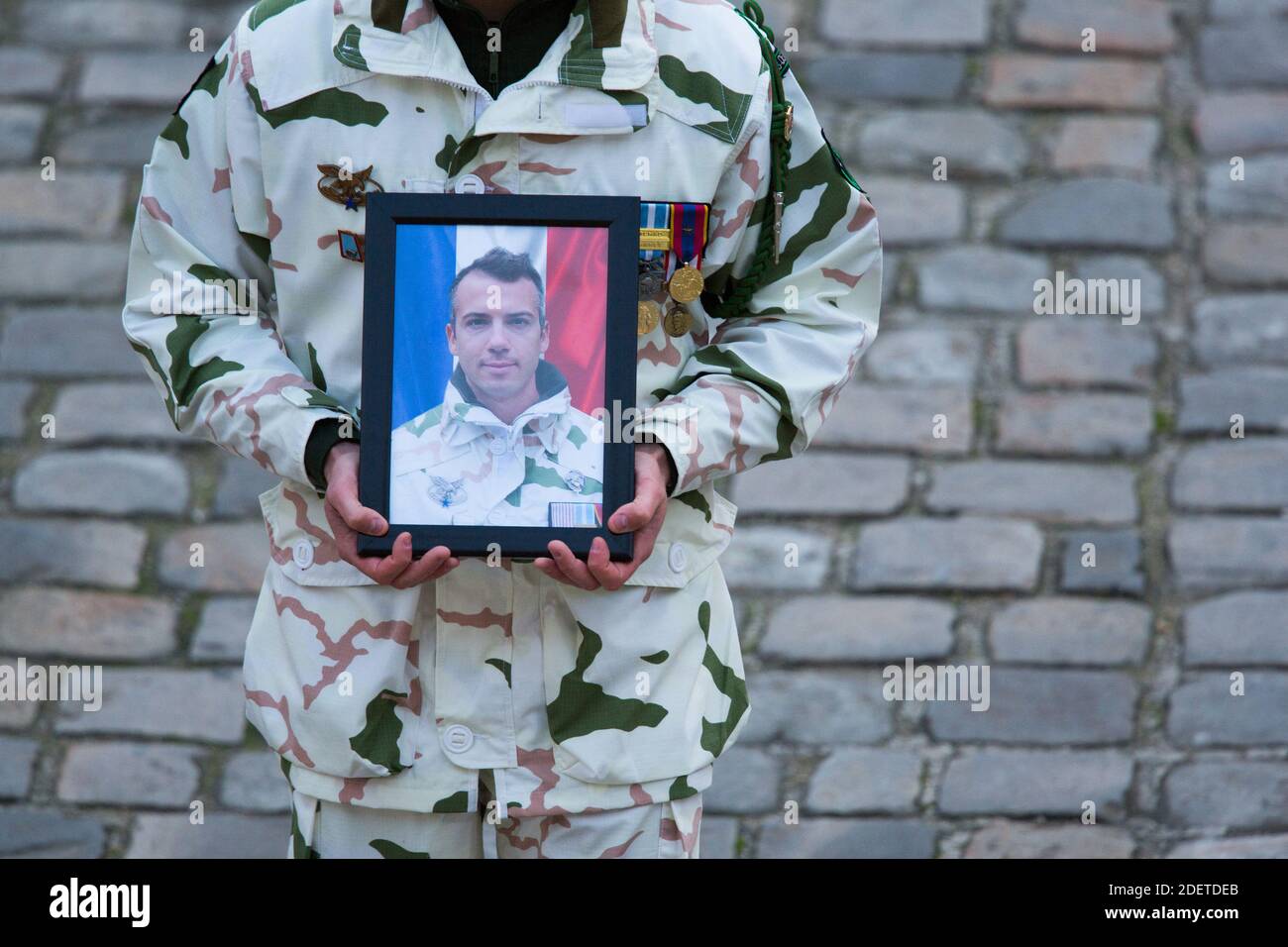 Soldiers carry away the pictures of the 13 French soldiers killed in ...