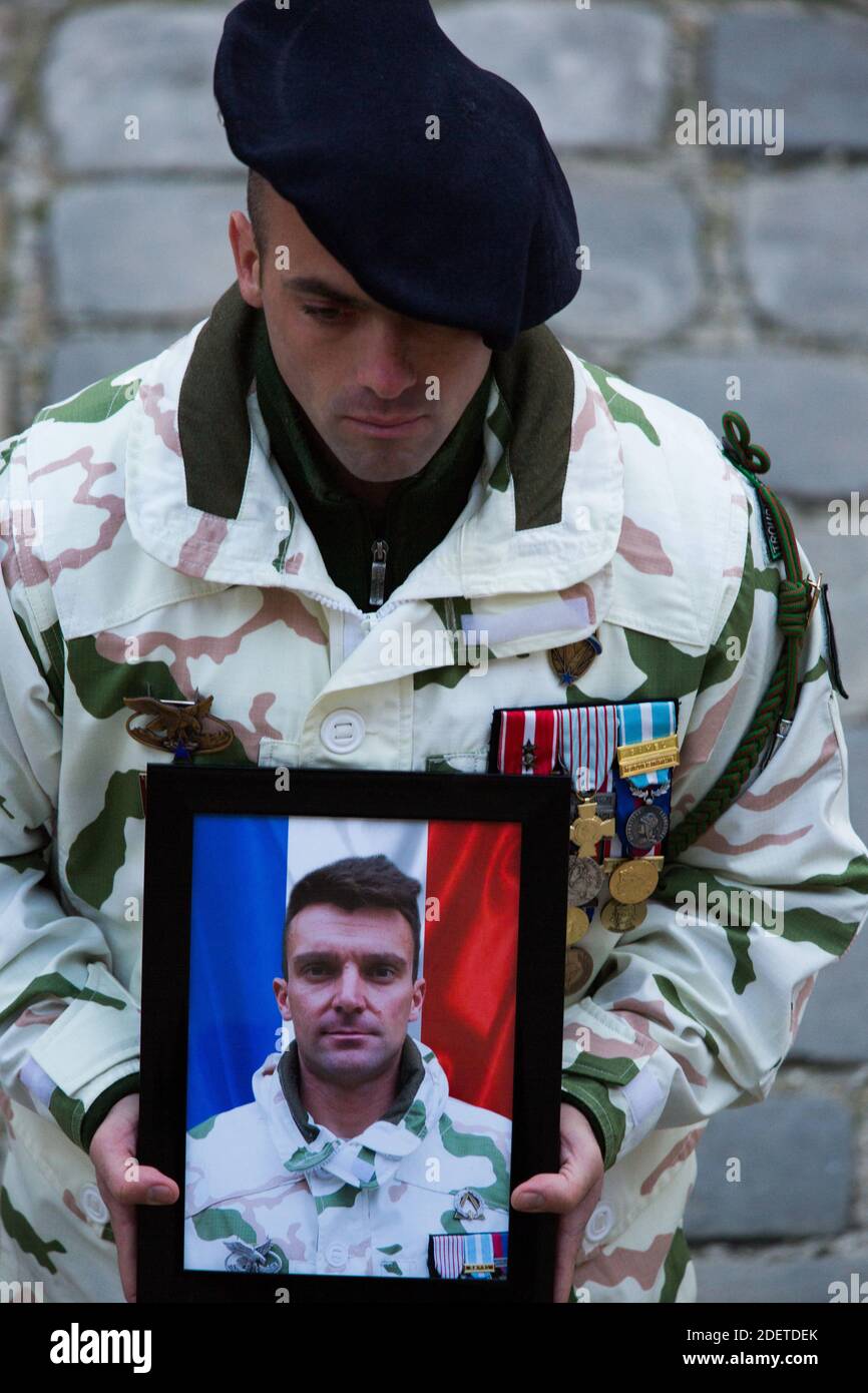 Soldiers carry away the pictures of the 13 French soldiers killed in ...