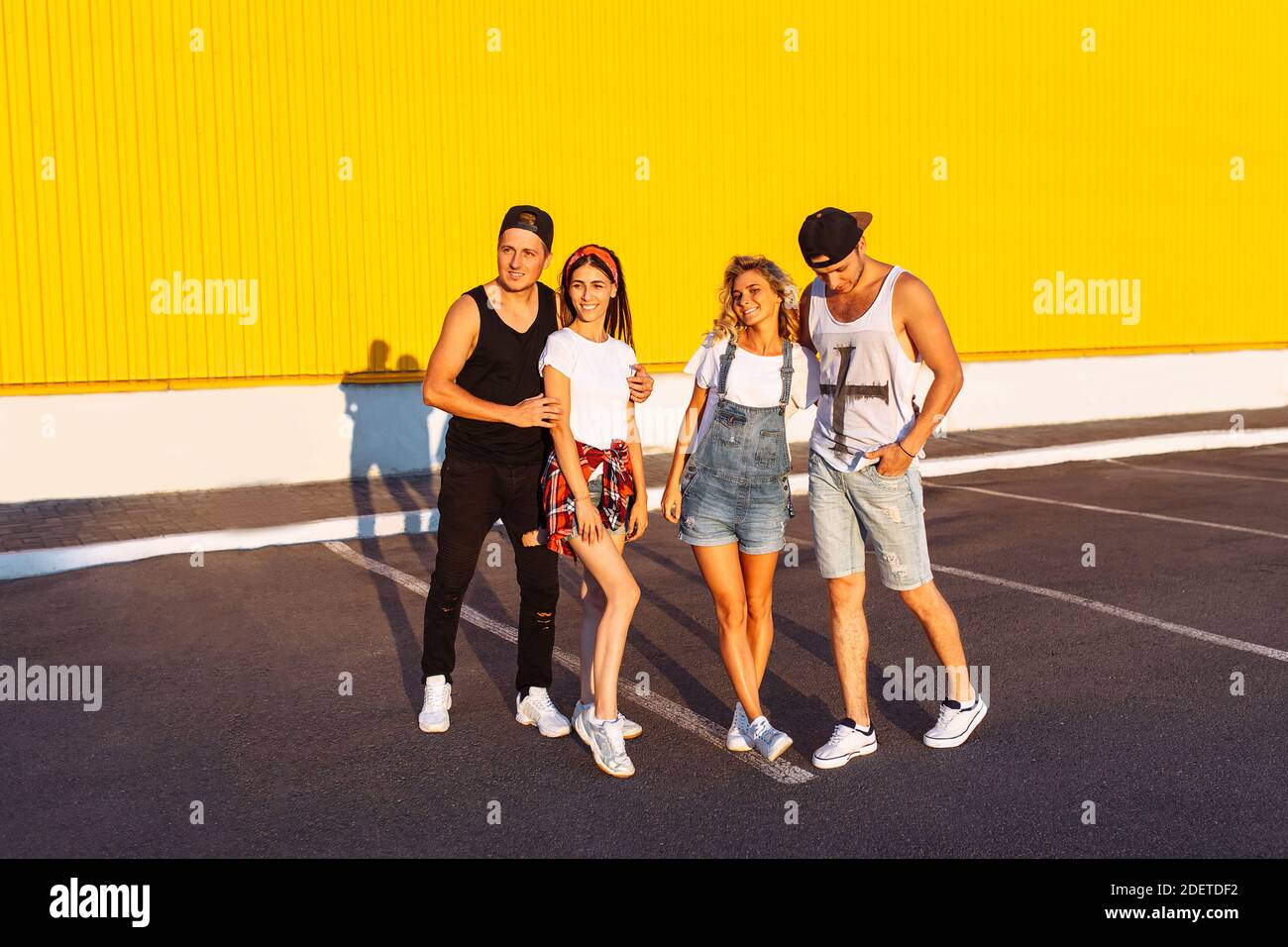 Beautiful cool young people posing on a yellow background, a group of ...