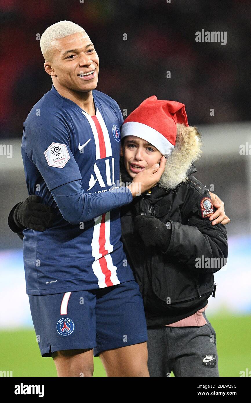 Kylian Mbappe of Paris Saint-Germain with a child who invaded the field ...