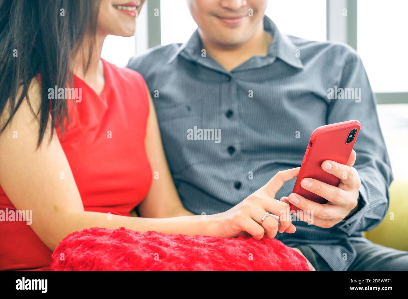 Beautiful romantic couple in love looking at smart phone at home ...
