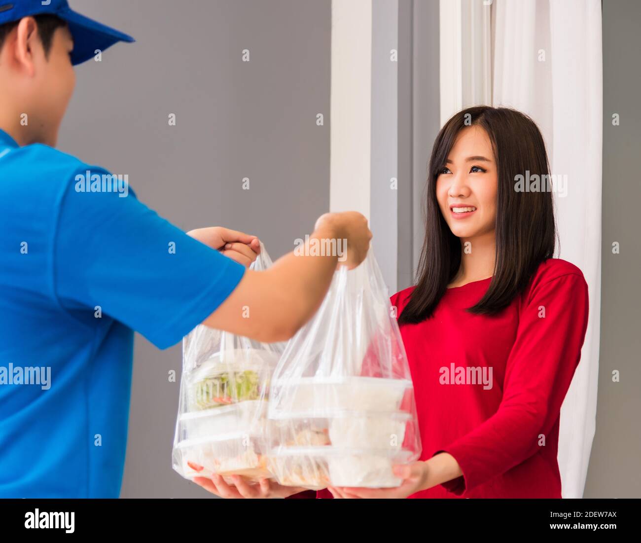 Asian young delivery man in blue uniform he making grocery service ...