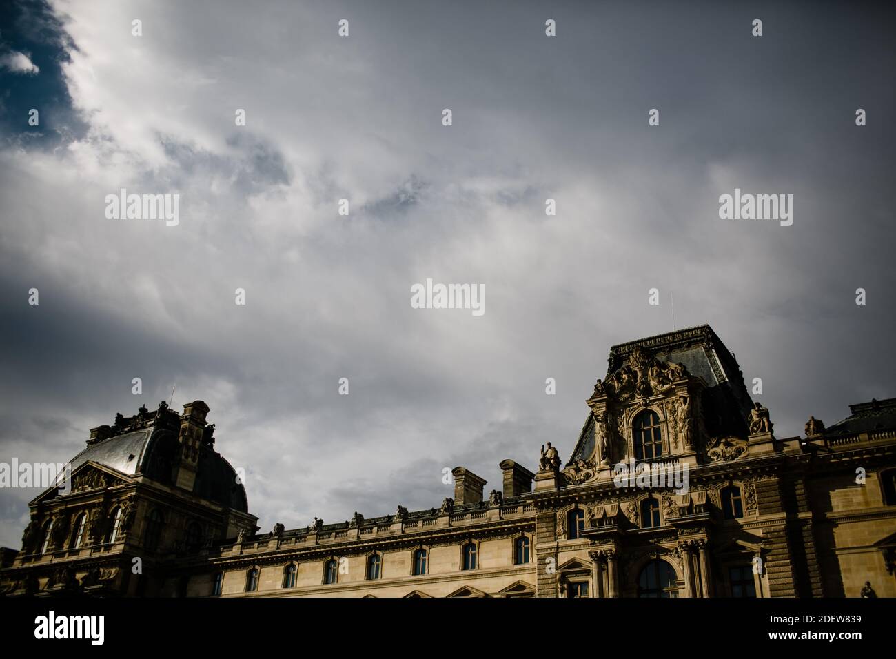 View outside of the Louvre with Clouds in Sky Stock Photo - Alamy