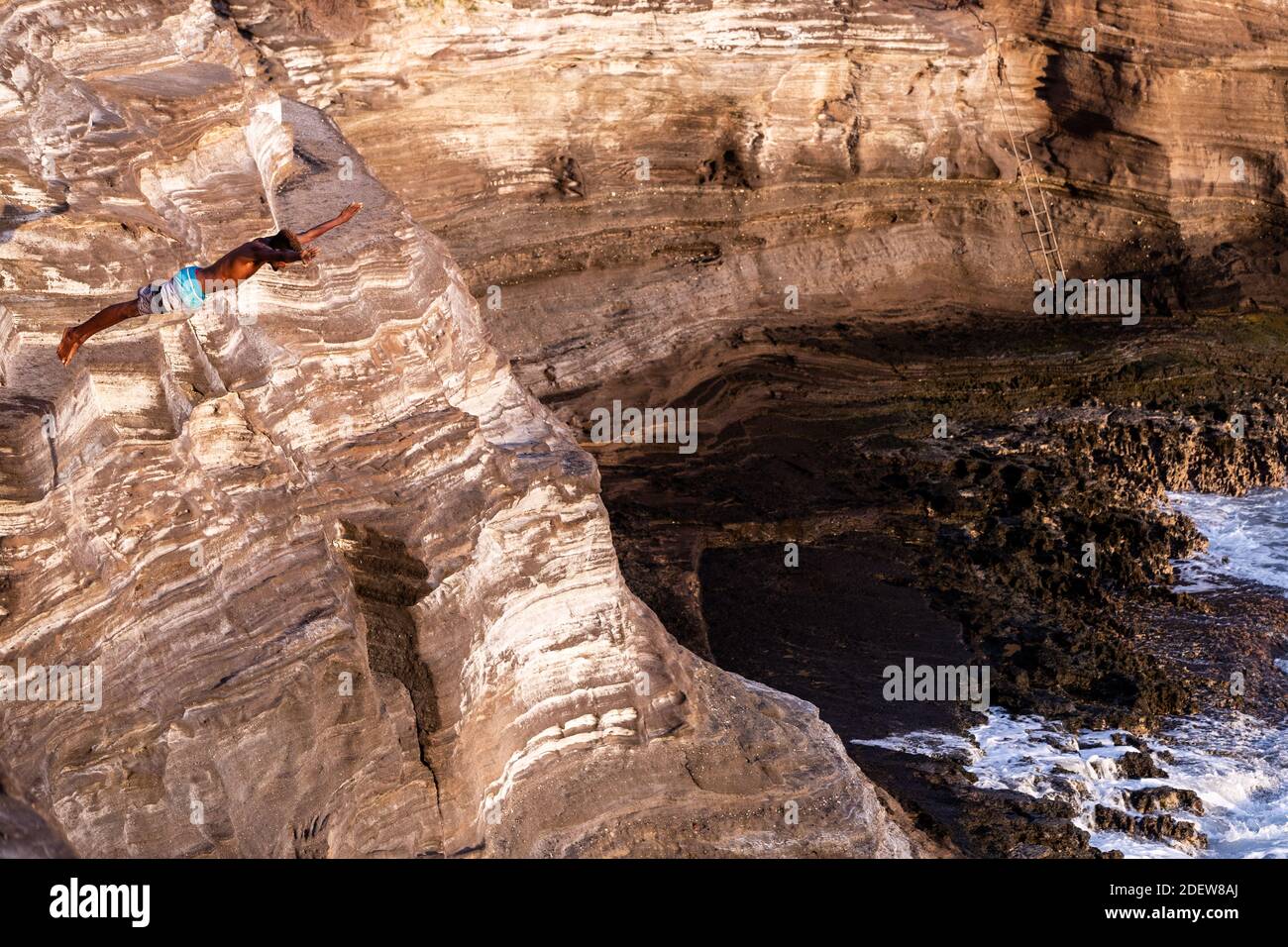 Black male cliff diver dives into the ocean in hawaii Stock Photo - Alamy