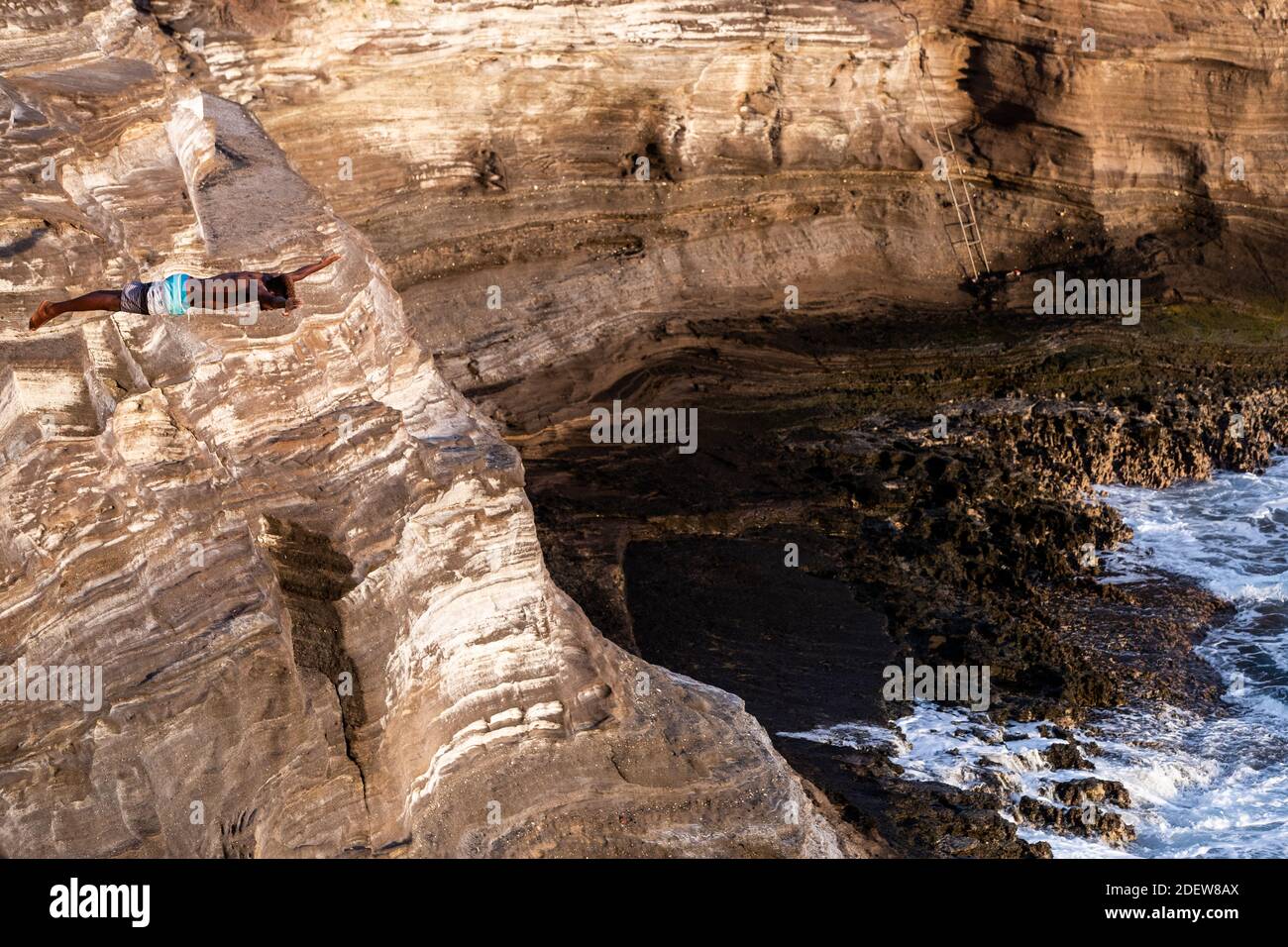 Male cliff diver jumps into the ocean in hawaii Stock Photo - Alamy