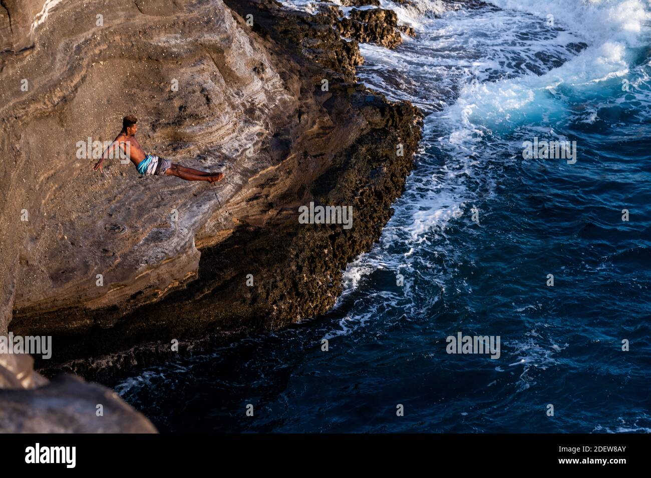 Athletic male cliff diver jumps into ocean in oahu, hawaii Stock Photo ...