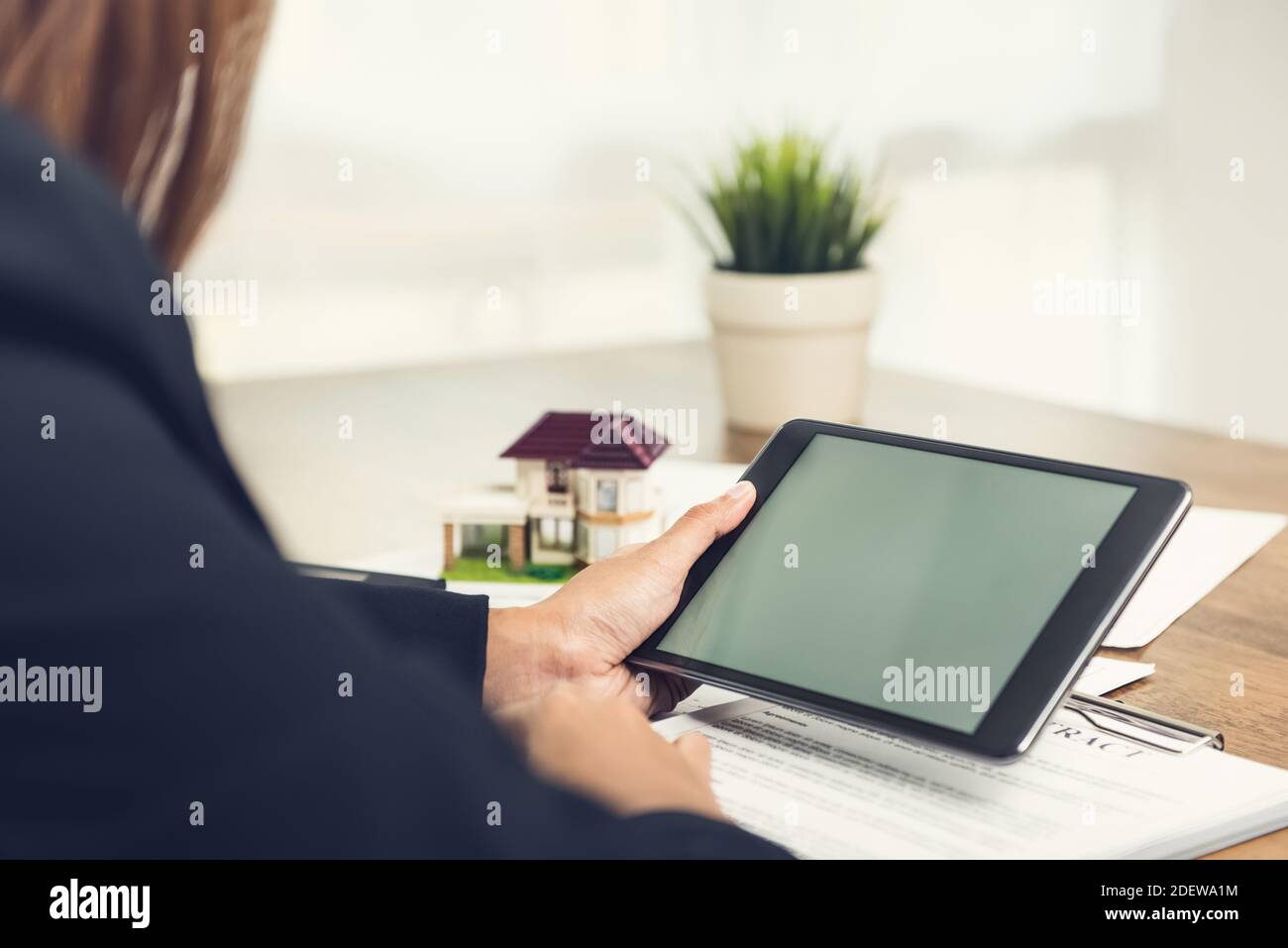 Real estate agent or architect working at her desk using technology on ...