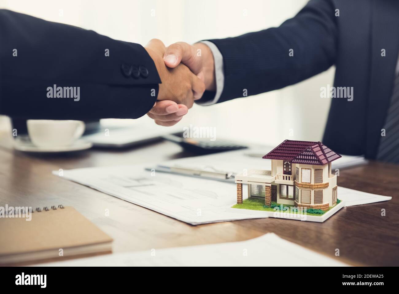 Real estate agent or architect making handshake with client after ...