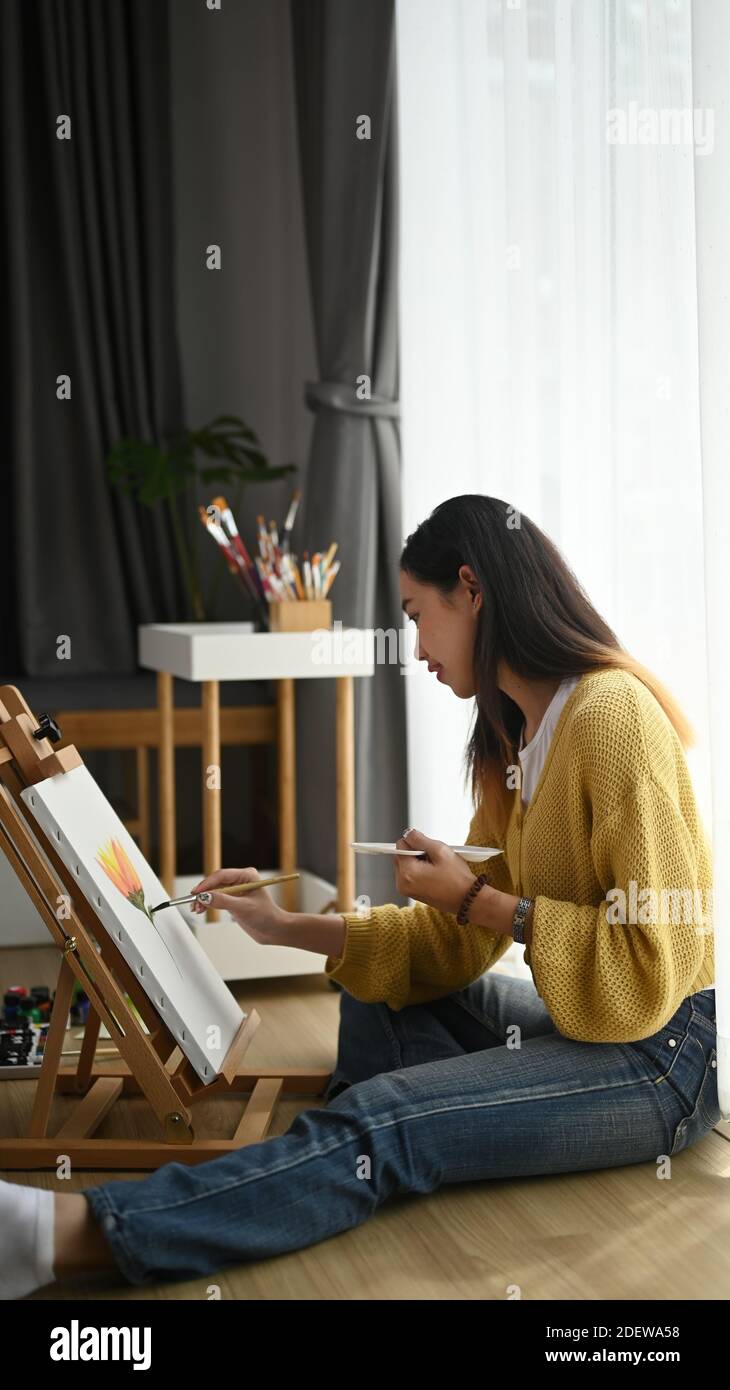 Side view of a young female painter painting in her workshop Stock ...