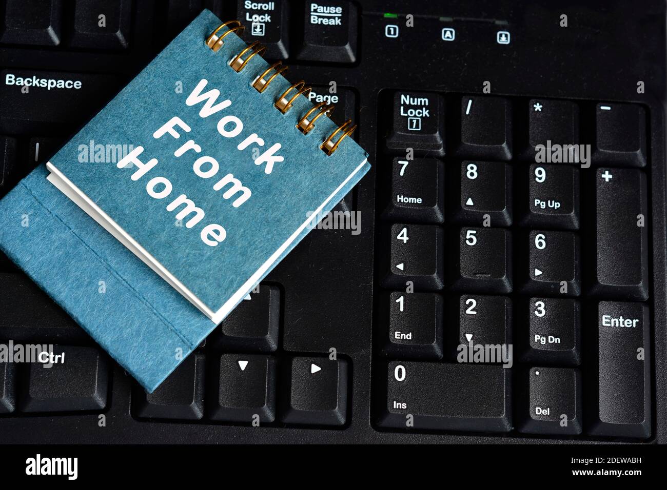 Blue notebook with text written on top of black keyboard on the table ...