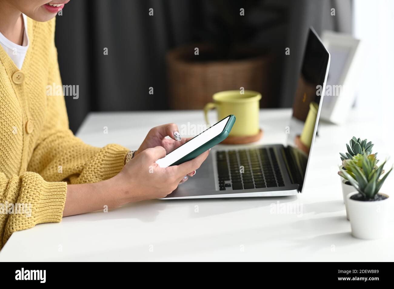 Cropped shot of a woman is using smartphone for typing messages ...