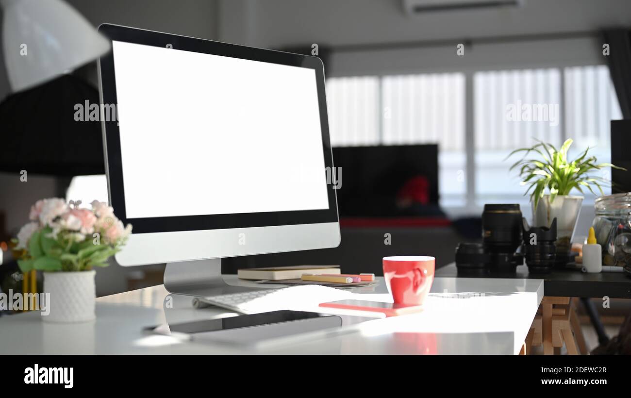 Contemporary workspace with blank screen computer and office supplies ...