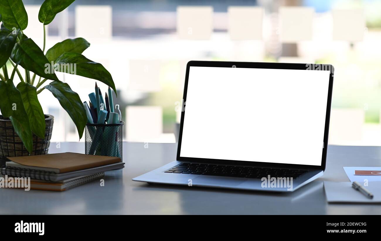 Designer comfortable workspace with empty screen laptop near the window ...