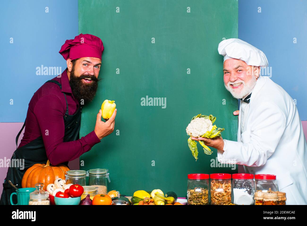 Portrait of a confident chef showing vegetables and fruits on copyspace ...