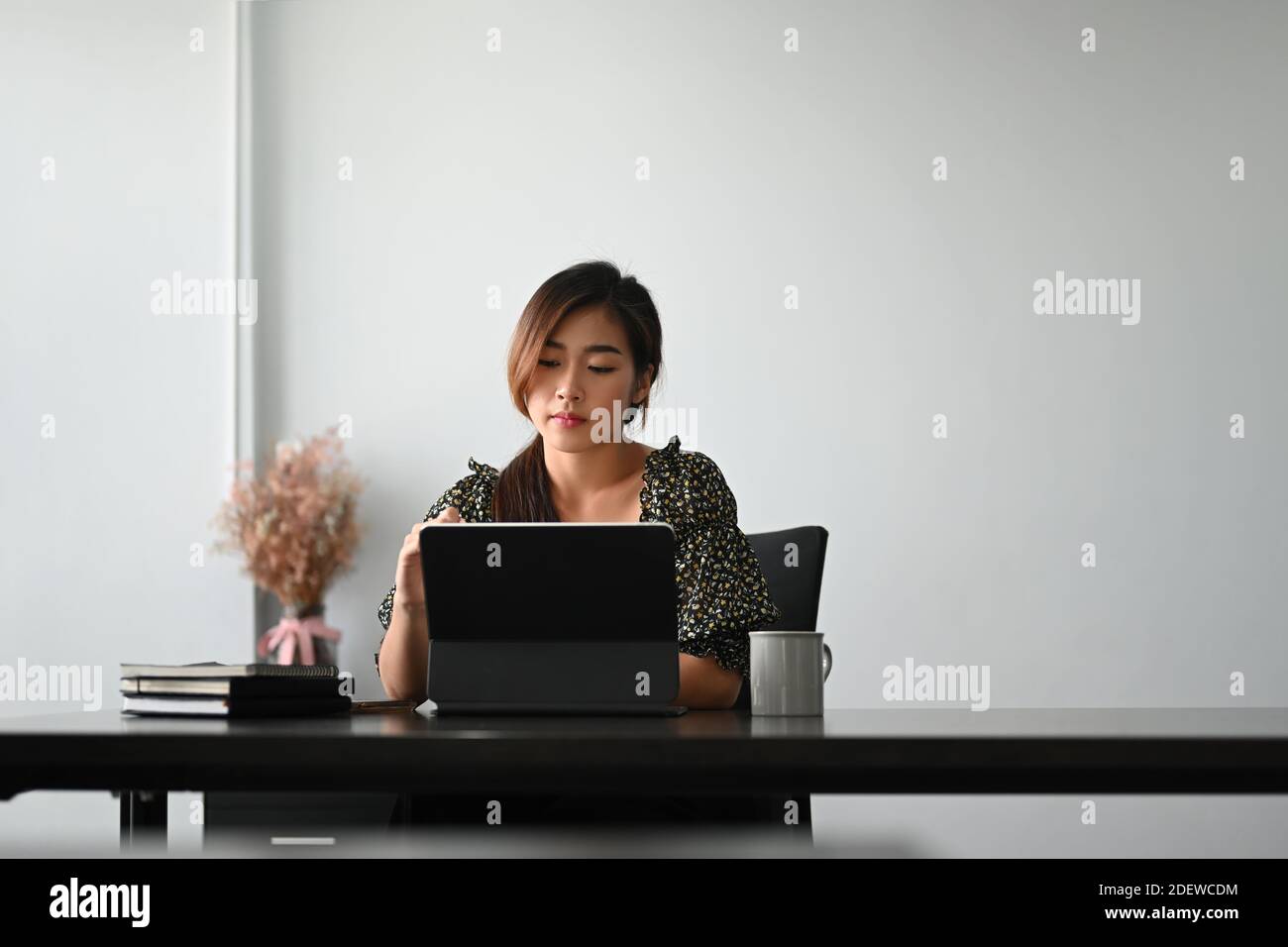 A businesswoman working at home using tablet computer with business ...