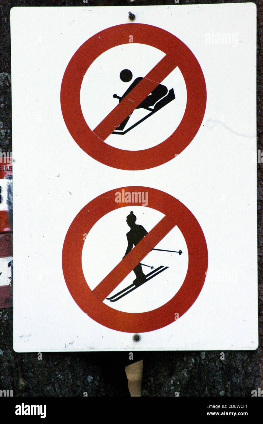 white sign with skiing safety instructions, pictogram in red crossed ...