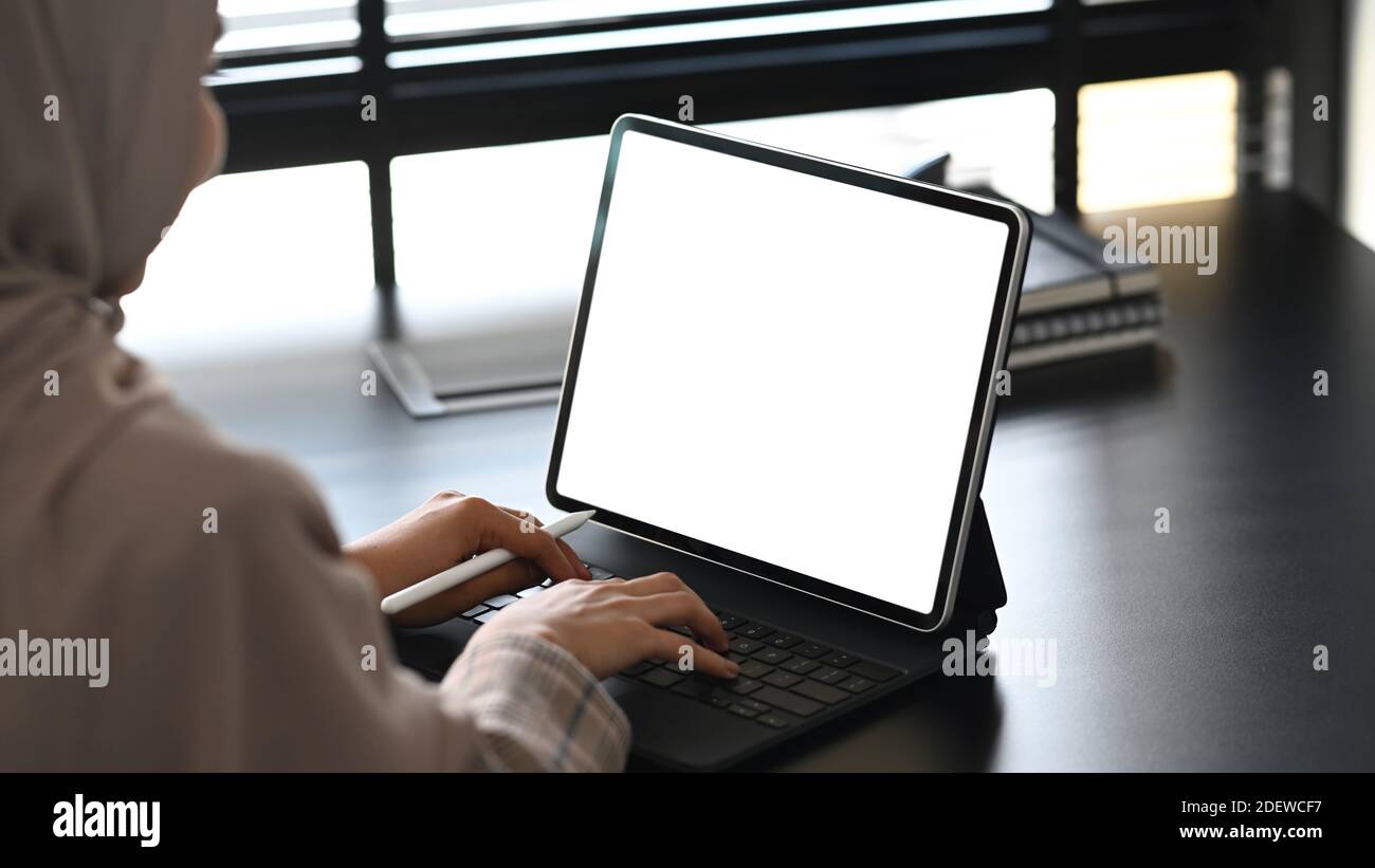 The backside of business muslim woman working on blank screen computer ...