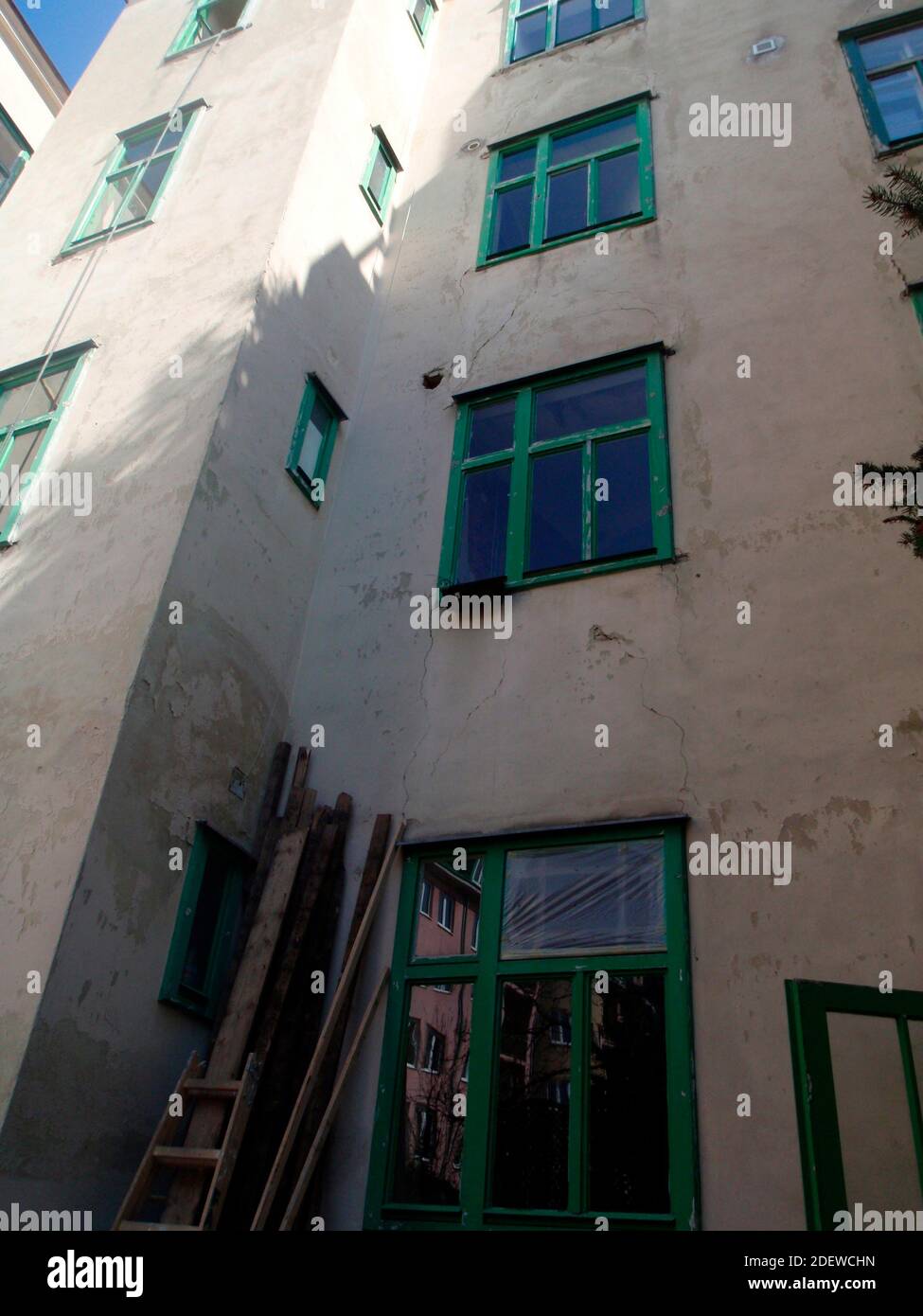 structural damage to house with a white facade and green framed windows ...