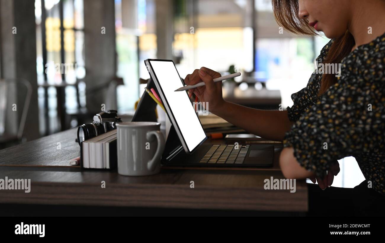 Croppeds shot of graphic designer using stylus pen writing on computer ...