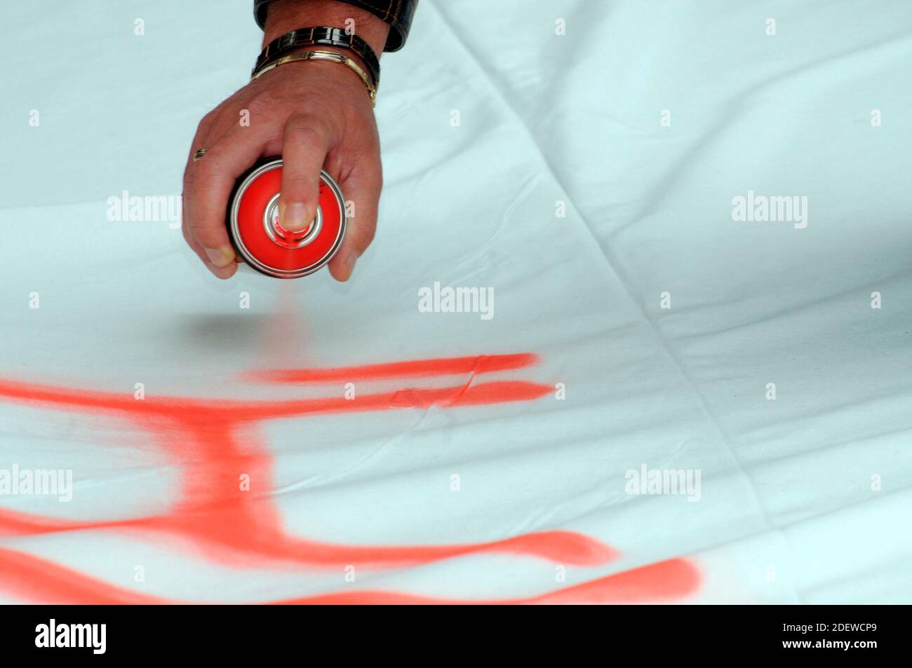 spraying red color with an aerosol can on a white blanket Stock Photo ...