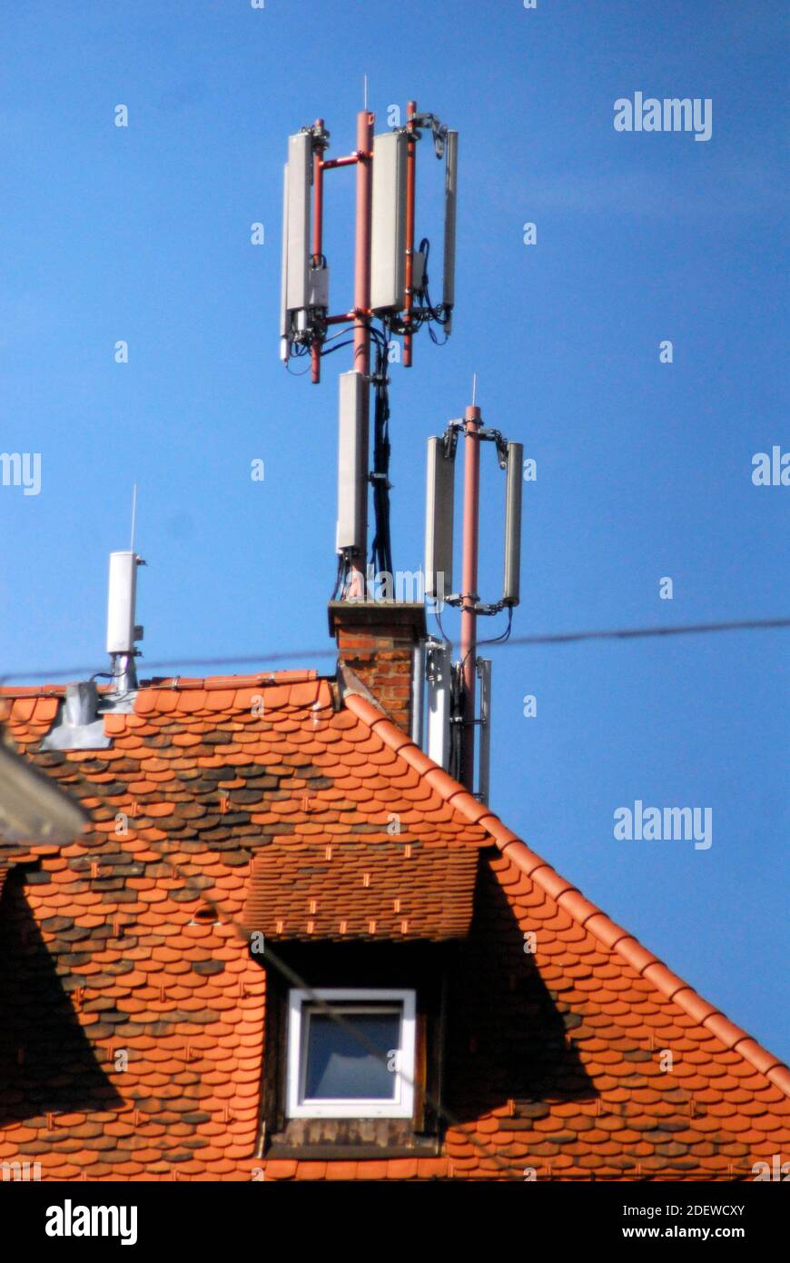 Mobile phone mast and antennas on the roof of a building in the city ...