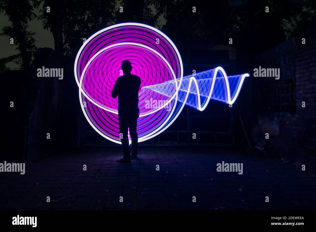 One person standing alone against beautiful color circle LED light ...