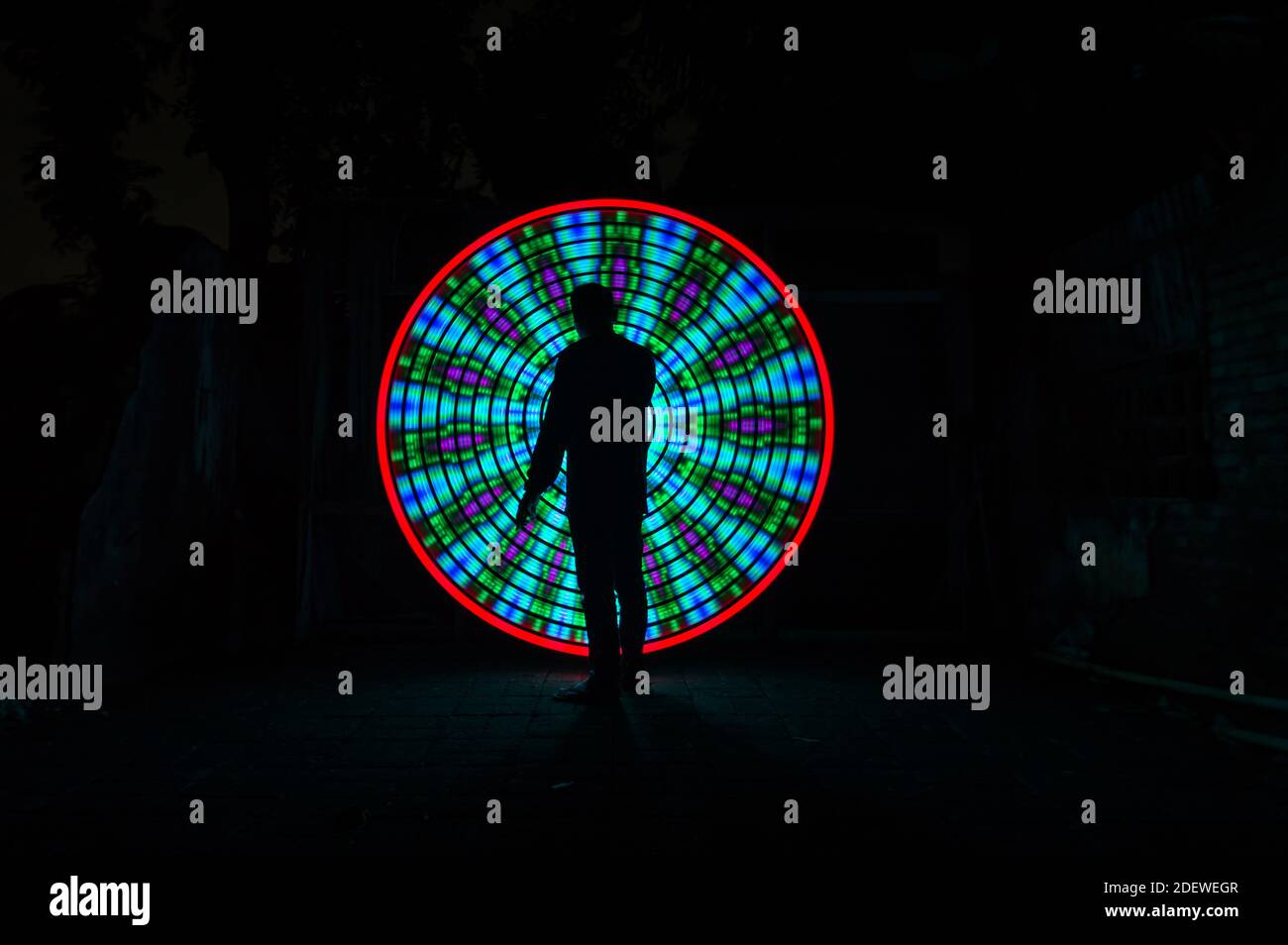 One person standing alone against beautiful color circle LED light ...