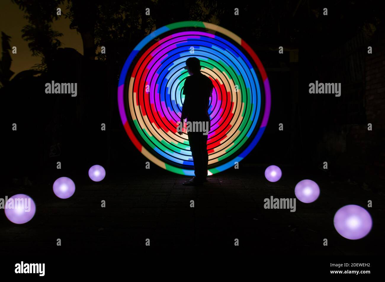 One person standing alone against beautiful color circle LED light ...