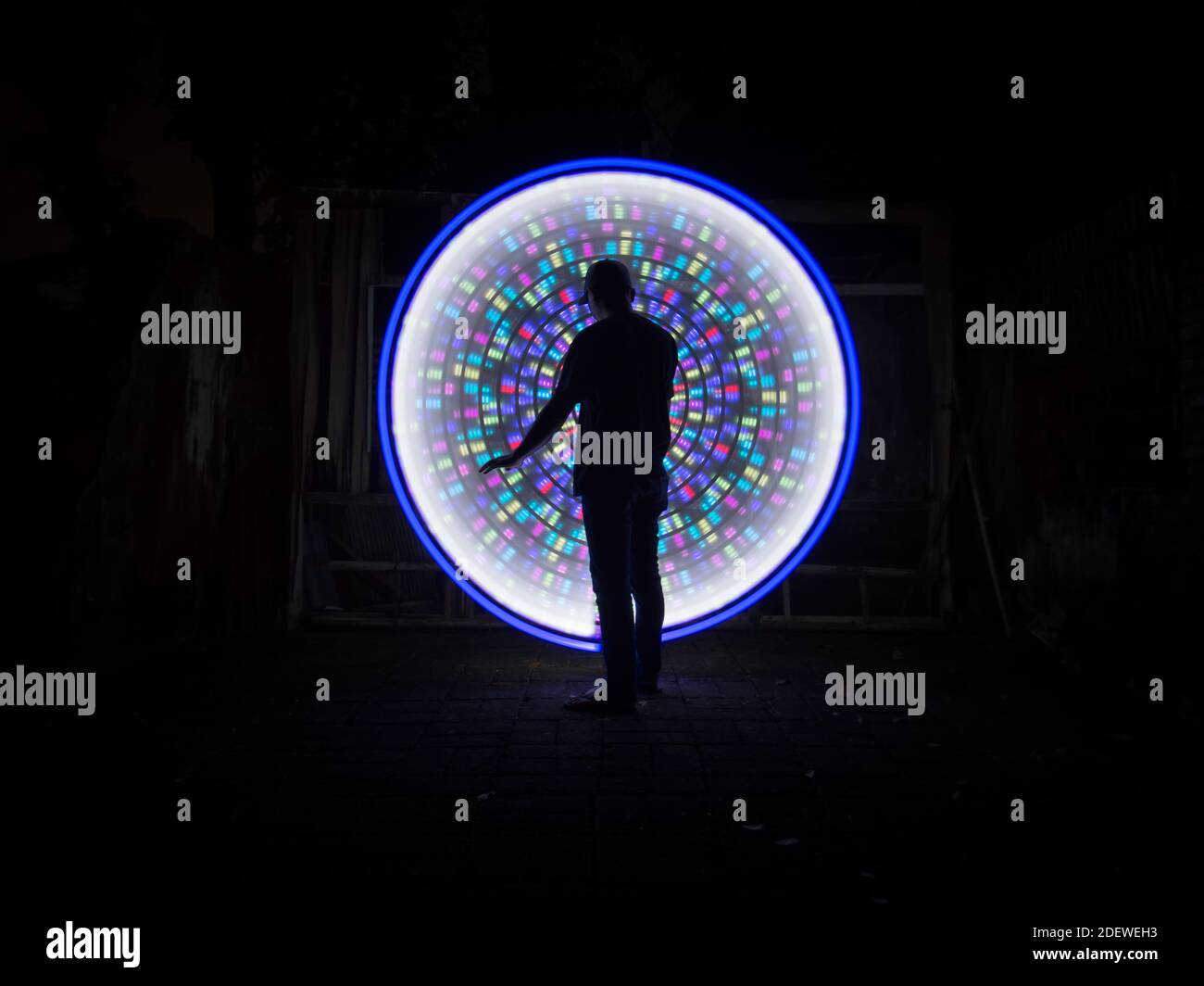 One person standing alone against beautiful color circle LED light ...