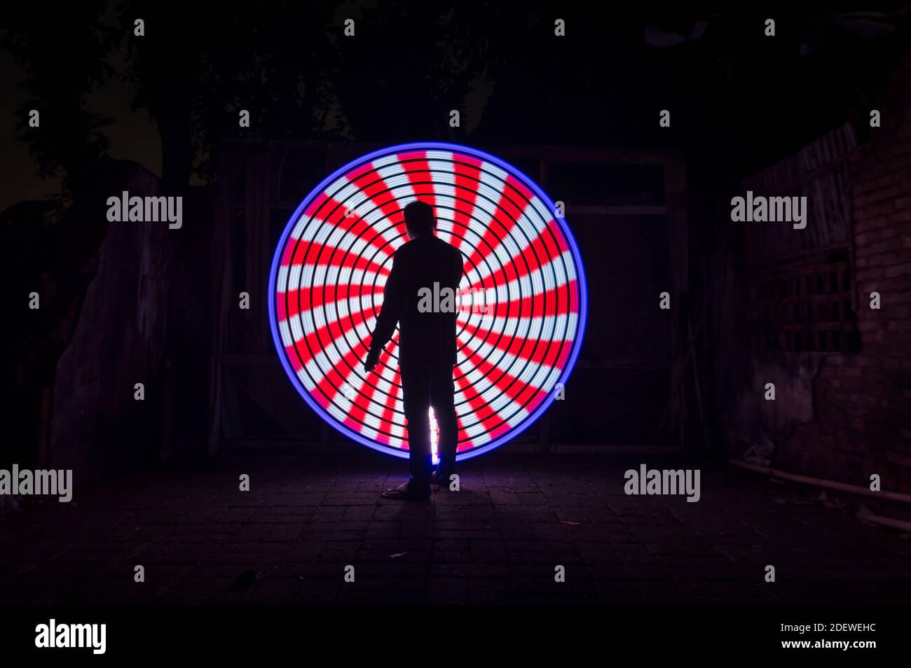One person standing alone against beautiful color circle LED light ...