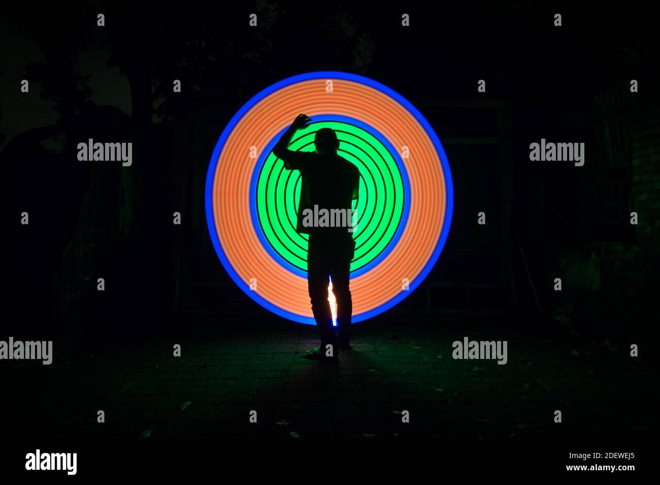 One person standing alone against beautiful color circle LED light ...