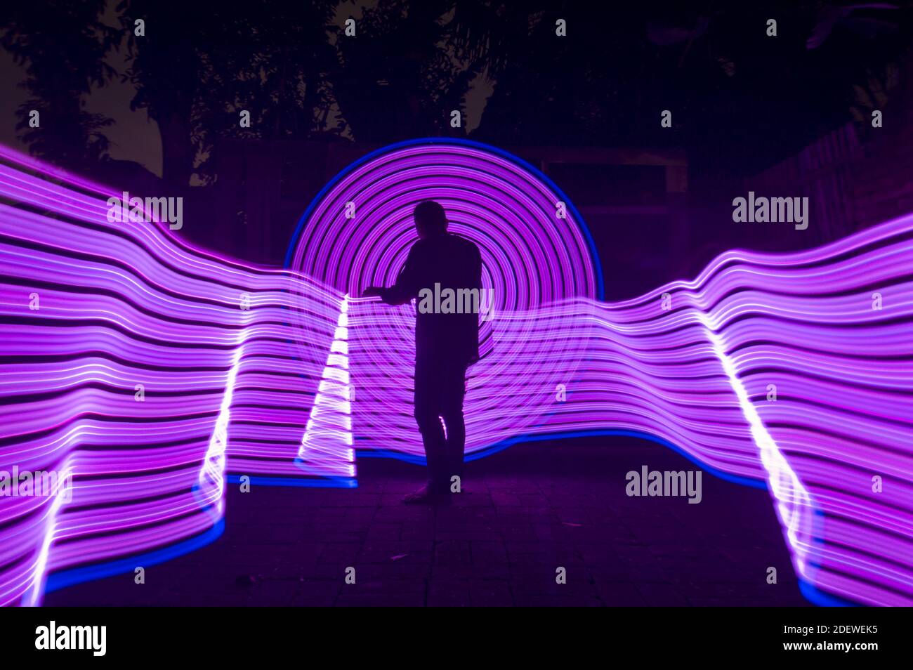 One person standing alone against beautiful color circle LED light ...