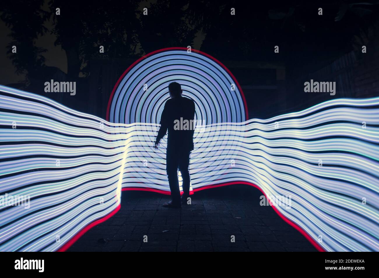 One person standing alone against beautiful color circle LED light ...