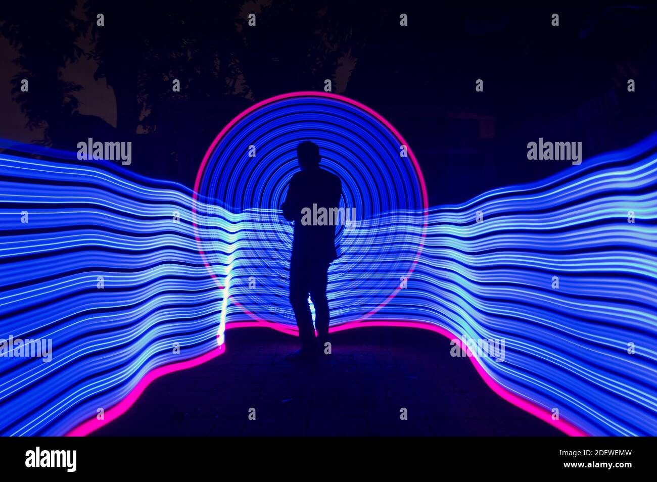 One person standing alone against beautiful color circle LED light ...