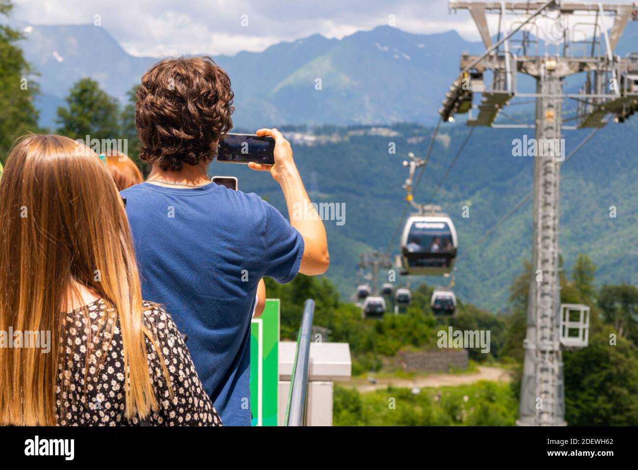 Man taking pictures of cable car on mobile smartphone Stock Photo - Alamy