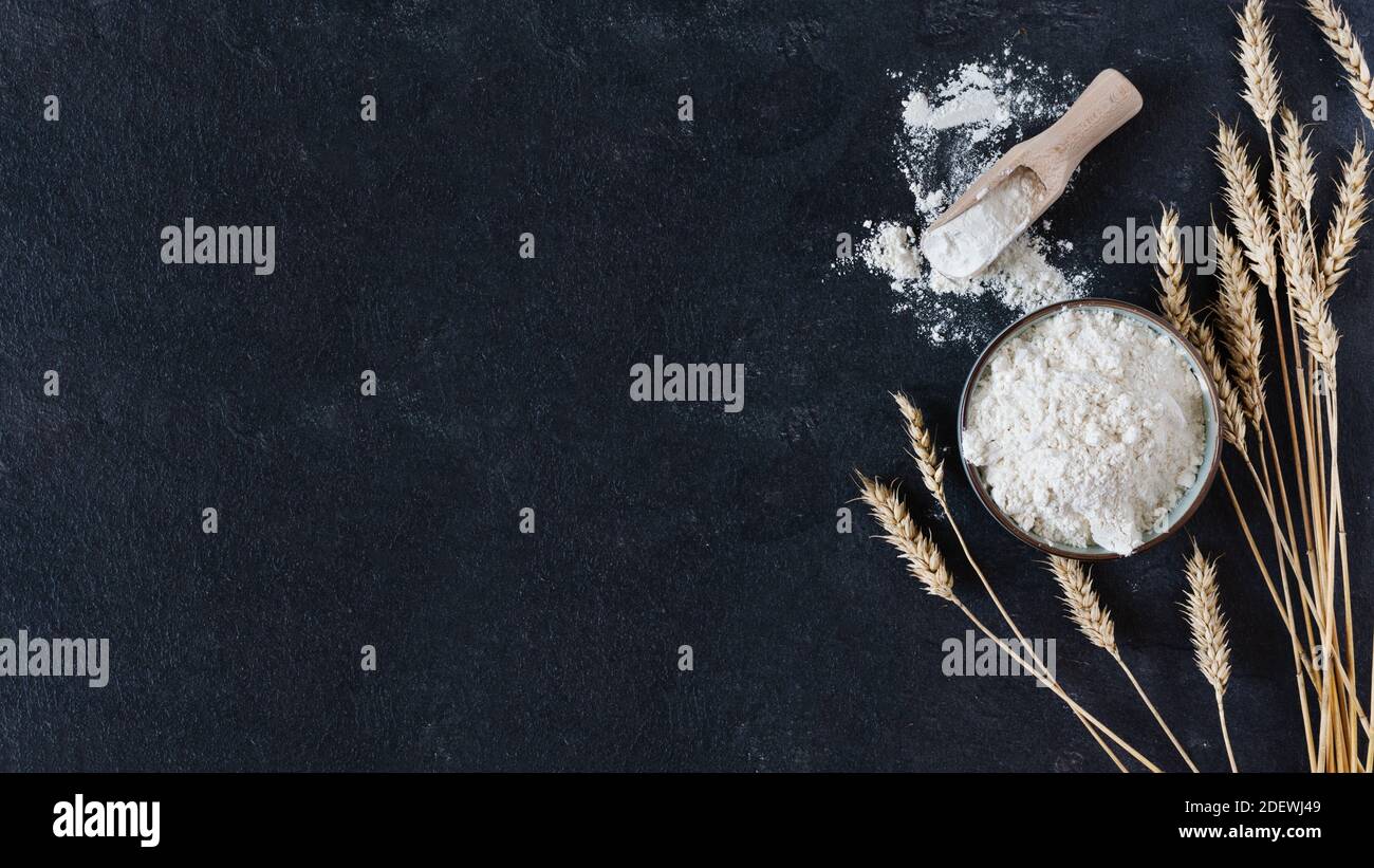 Bowl of wheat flour over black surface top view. Baking background for ...