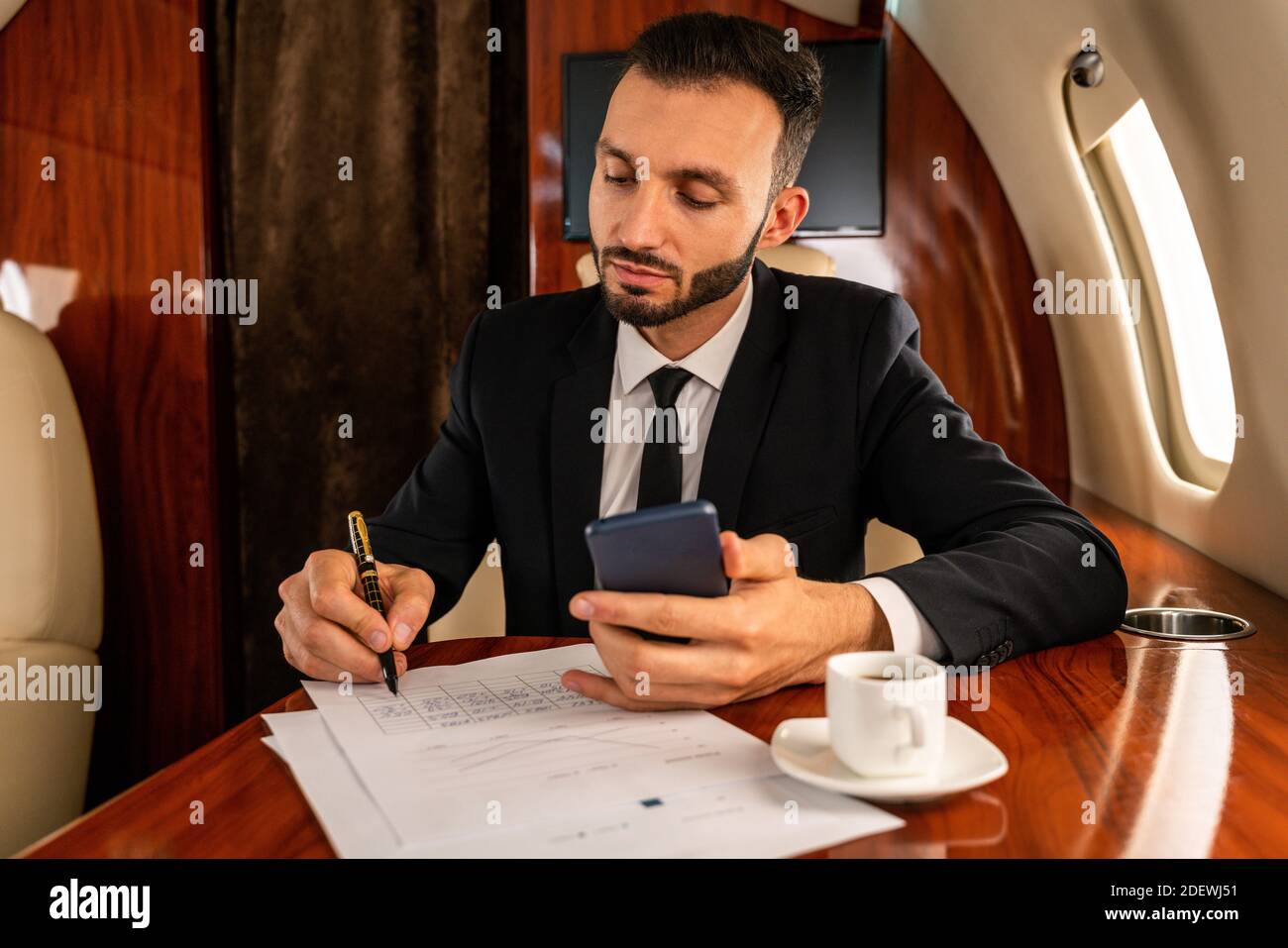 Handsome businessman wearing elegant suit flying on exclusive private ...