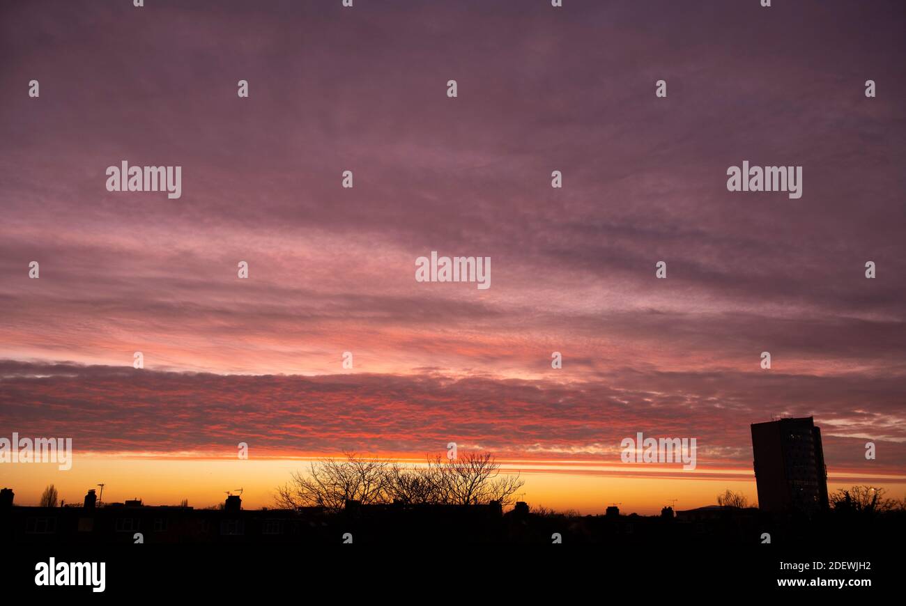 London, UK. 2 December 2020. Horizontal cloud layer is illuminated by ...