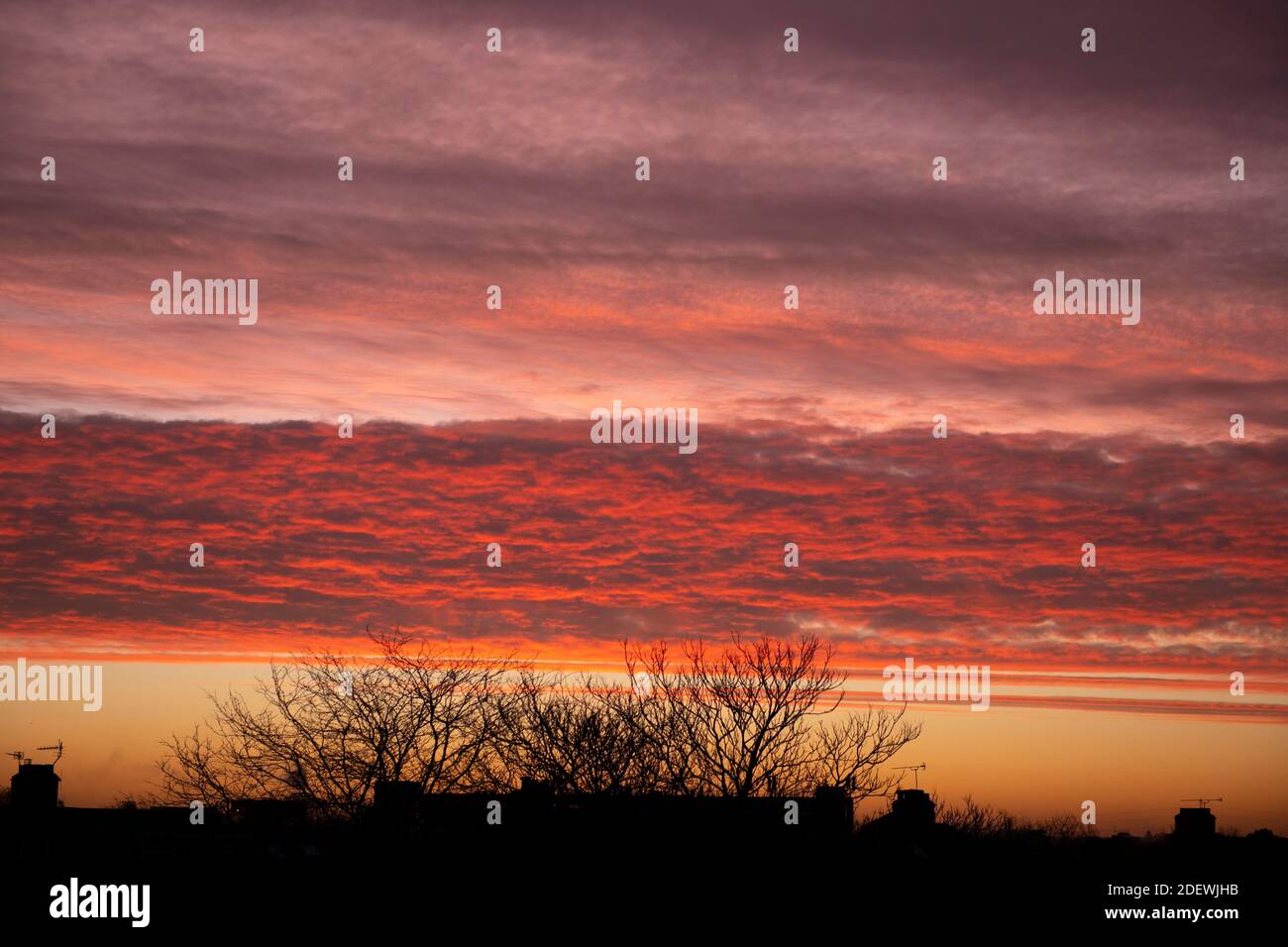 London, UK. 2 December 2020. Horizontal cloud layer is illuminated by ...
